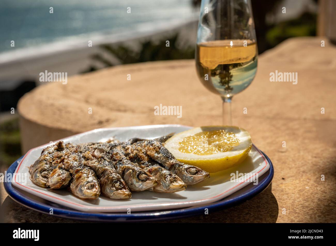 Sardines espeto prepared on skewers and open flame on fireplace with ...