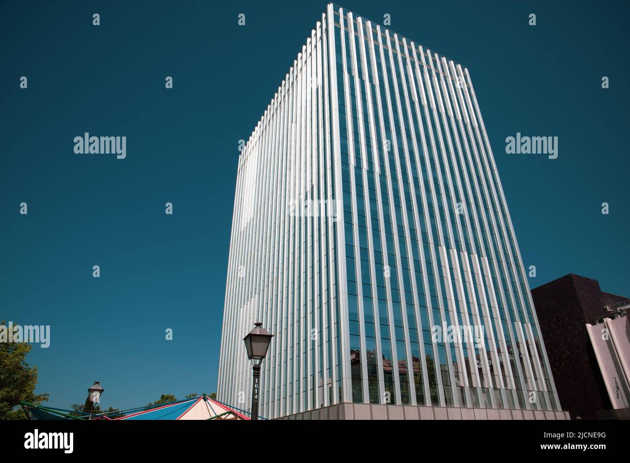 Modern tall multistory building glass facade against blue dramatic sky ...