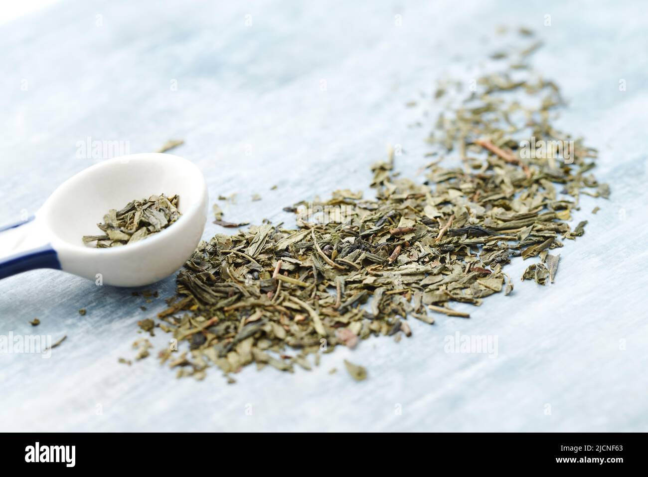 Dried Green Tea Leaves on Bright Wooden Background. Close up. Copy ...
