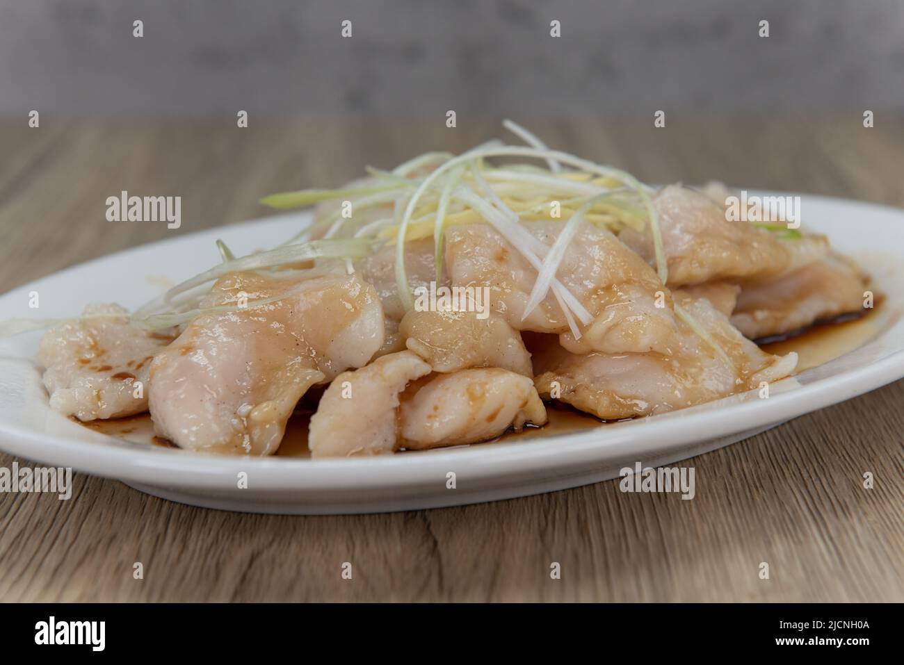 Steamed fish fillets in ginger sauce and piled high on the plate for a ...