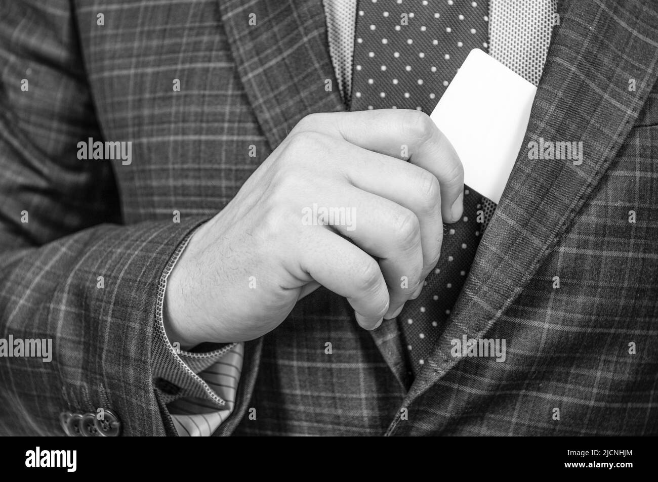 Male hand pull identity card from formal suit jacket cropped view ...