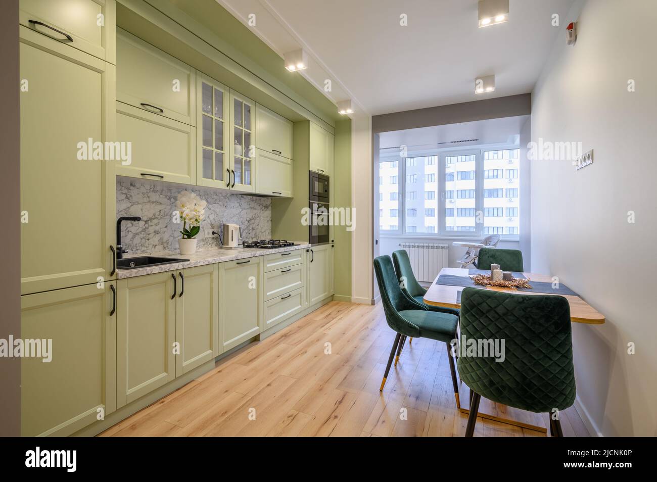Modern light green luxurious kitchen with dining table Stock Photo - Alamy