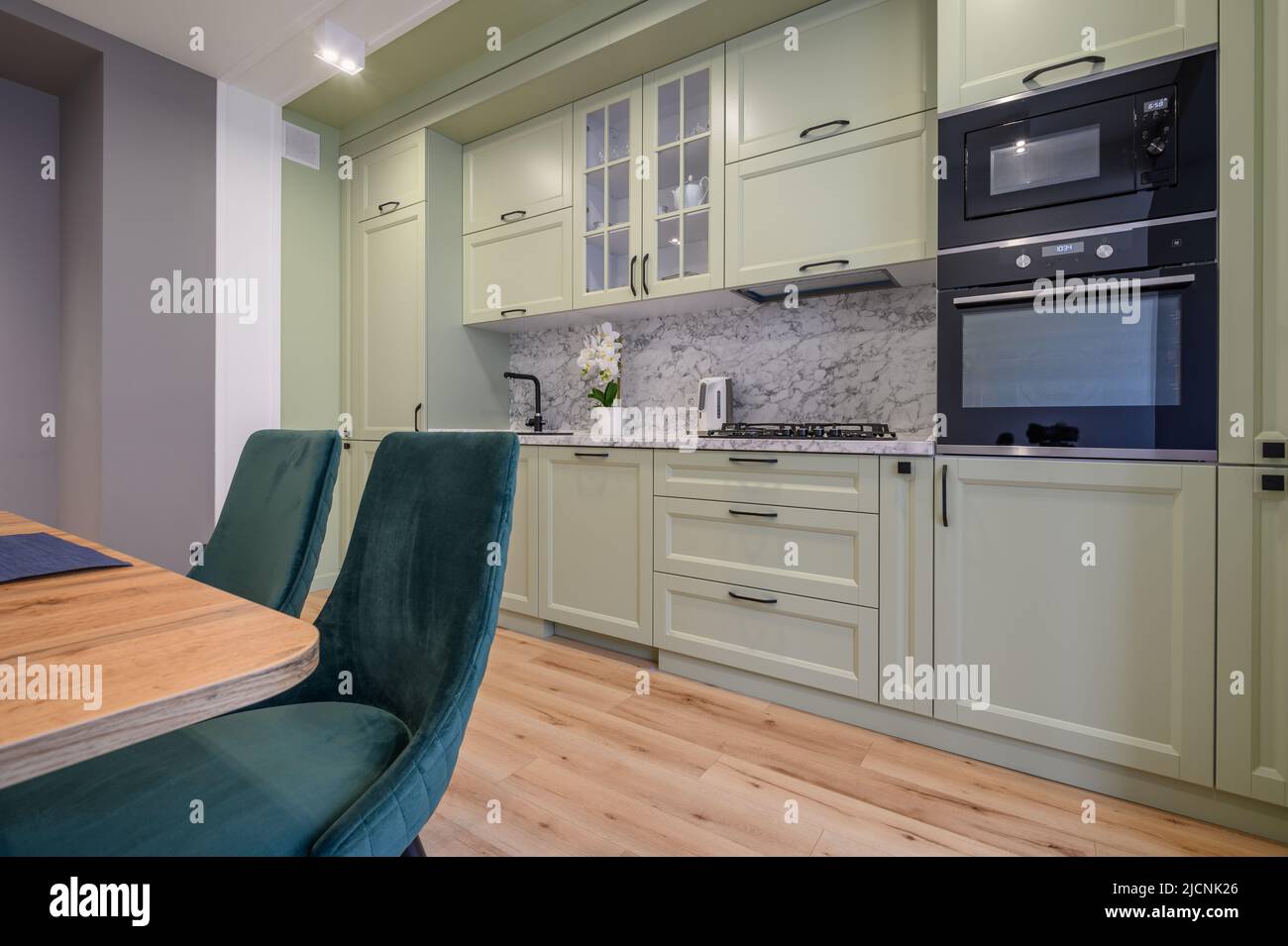 Modern light green luxurious kitchen with dining table Stock Photo - Alamy