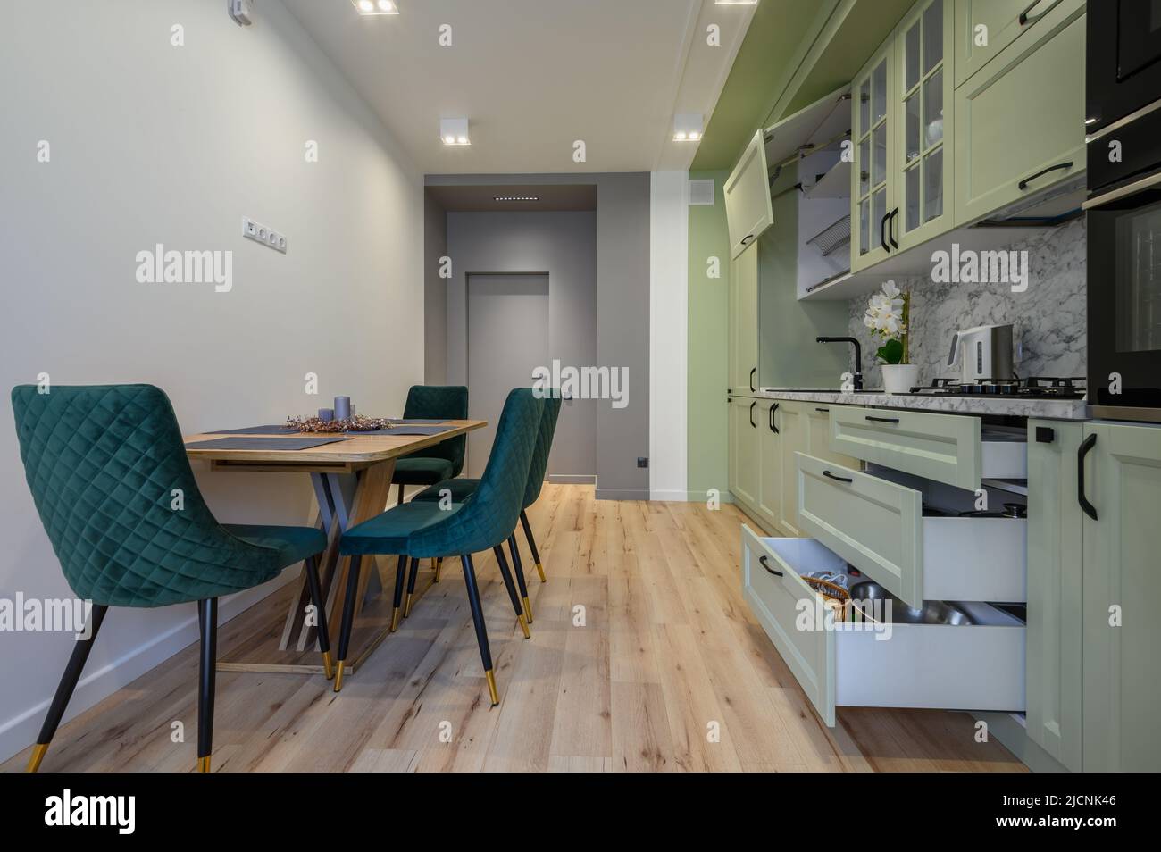 Modern light green luxurious kitchen with dining table Stock Photo - Alamy