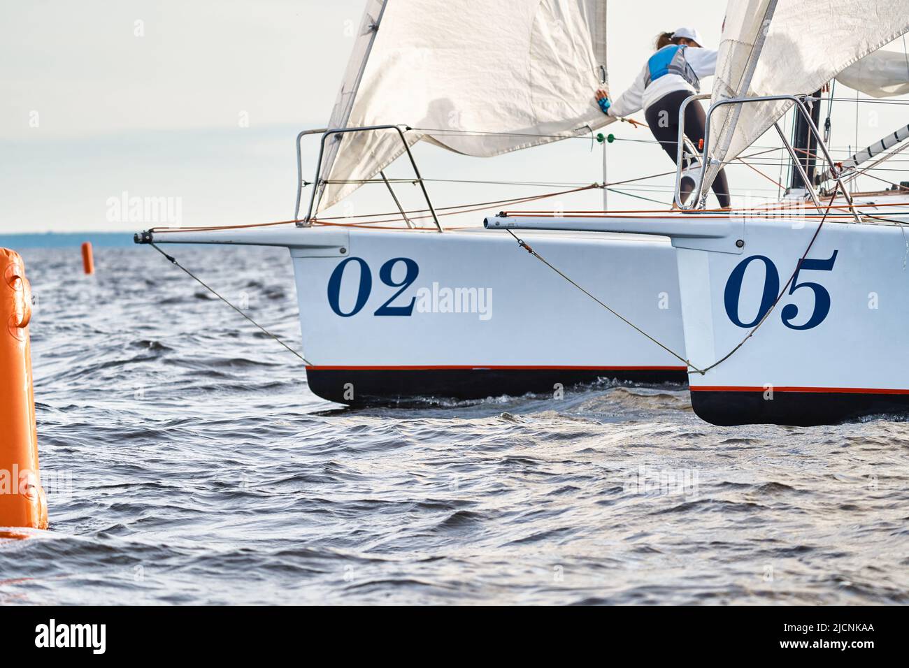 Bowsprits of sailing yachts in sailing regatta at sunset, still water ...