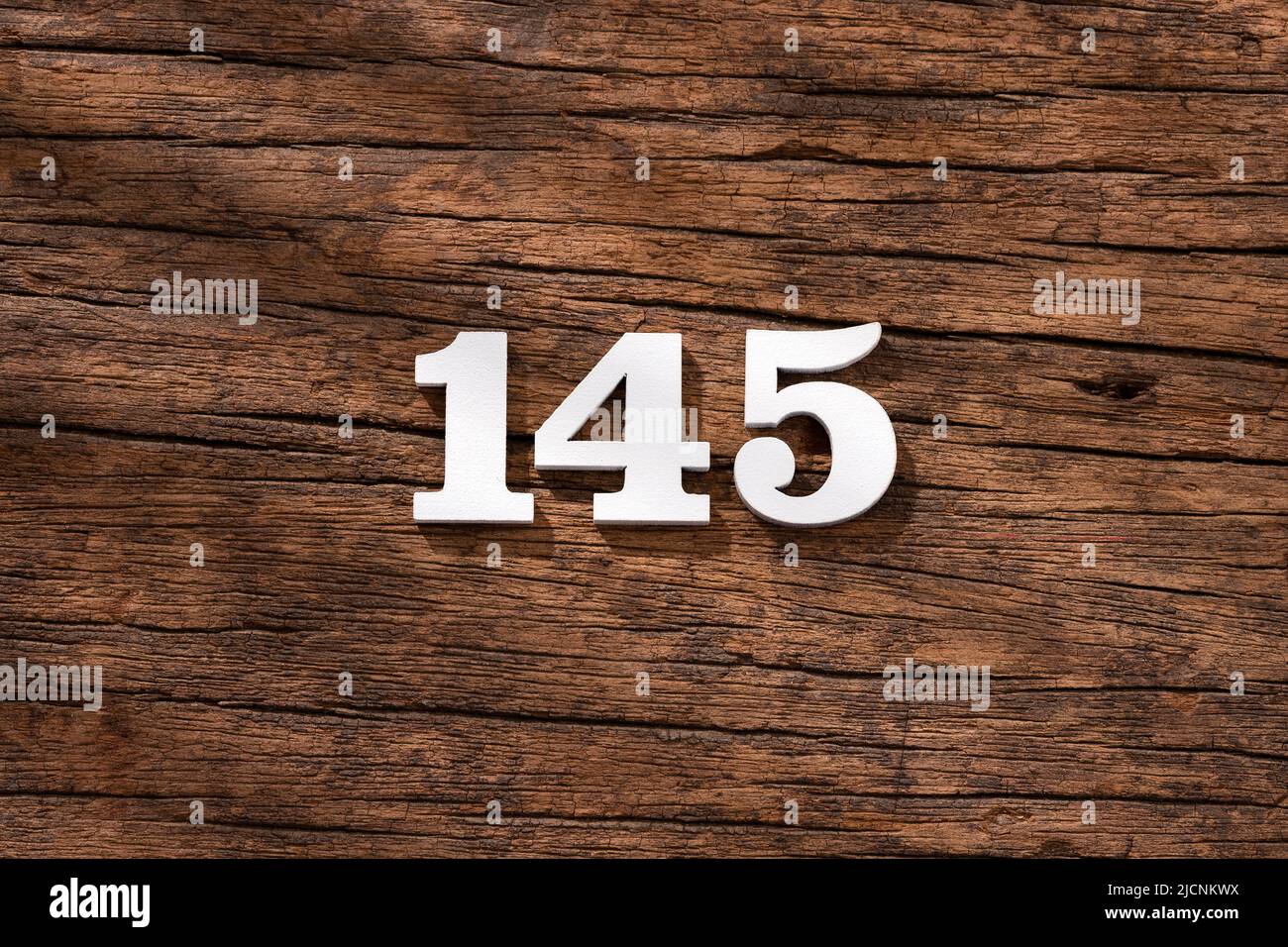 Number 145 - piece on rustic wood background Stock Photo - Alamy