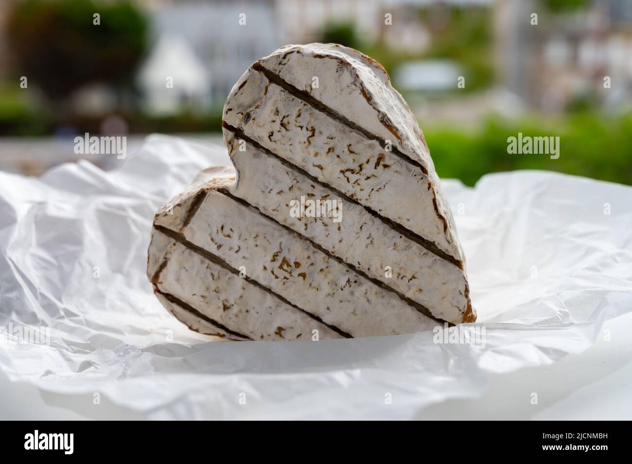 French heartshaped whole piece of neufchatel cow cheese on white paper ...