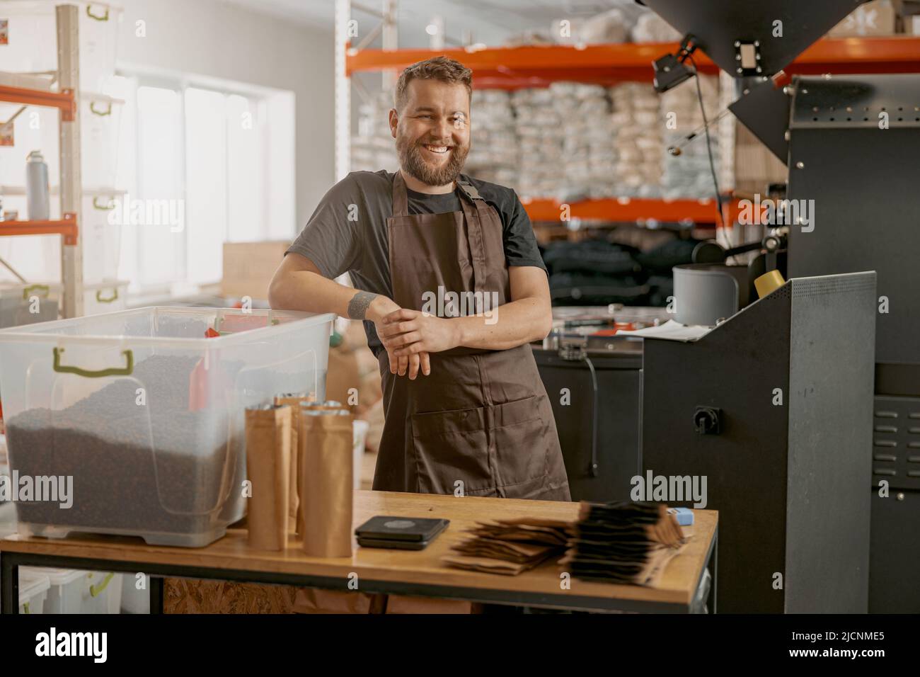 Smiling coffee roasting factory owner on his workplace looking camera ...
