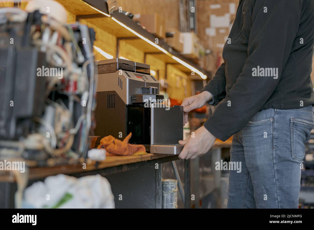 Professional worker inspecting detail of coffee machine in workshop ...