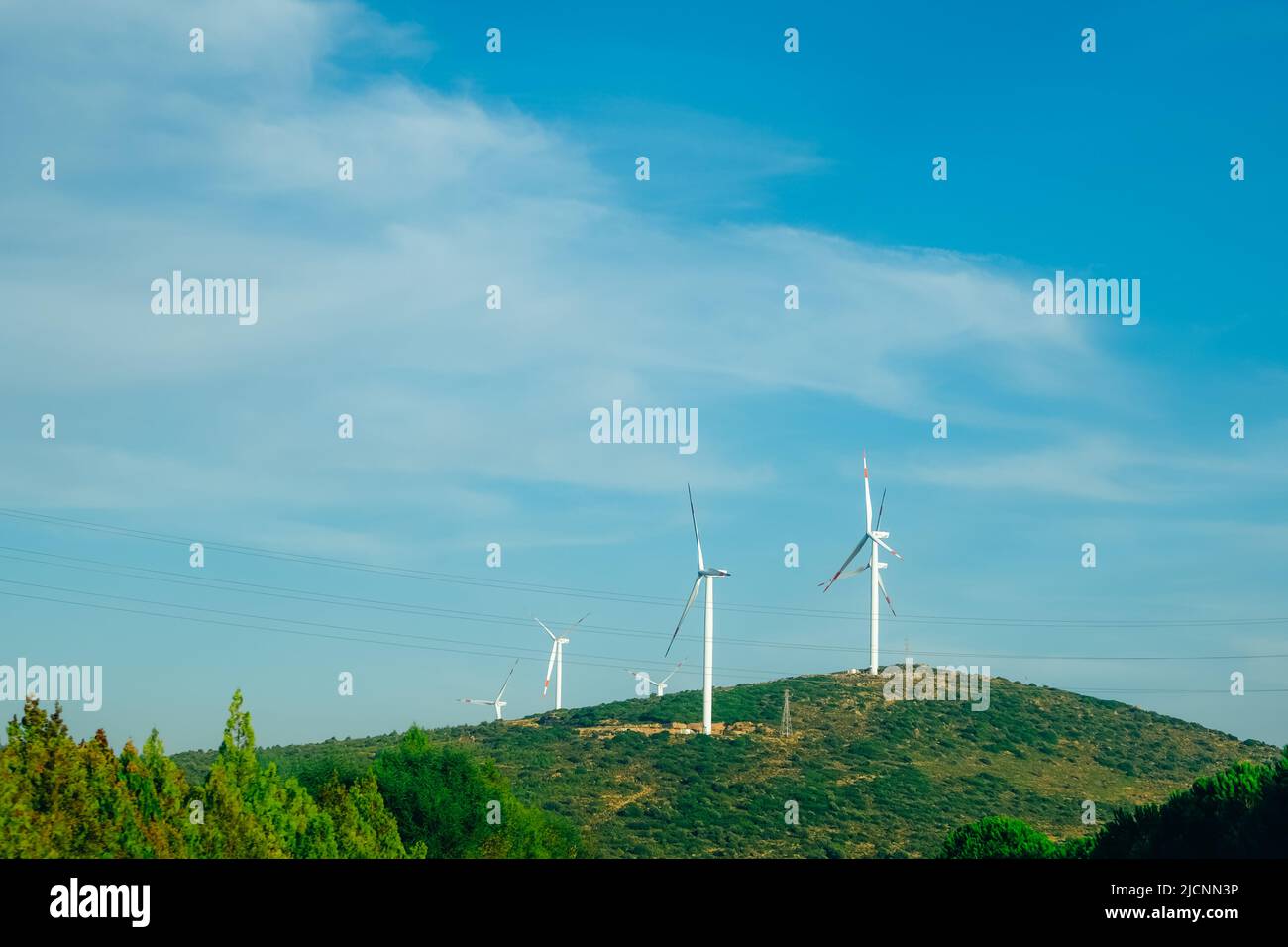 Wind farm with several wind turbines generating energy on the hill ...