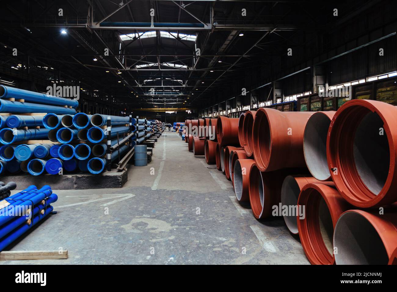 New cast iron pipes for pipeline construction in warehouse Stock Photo ...