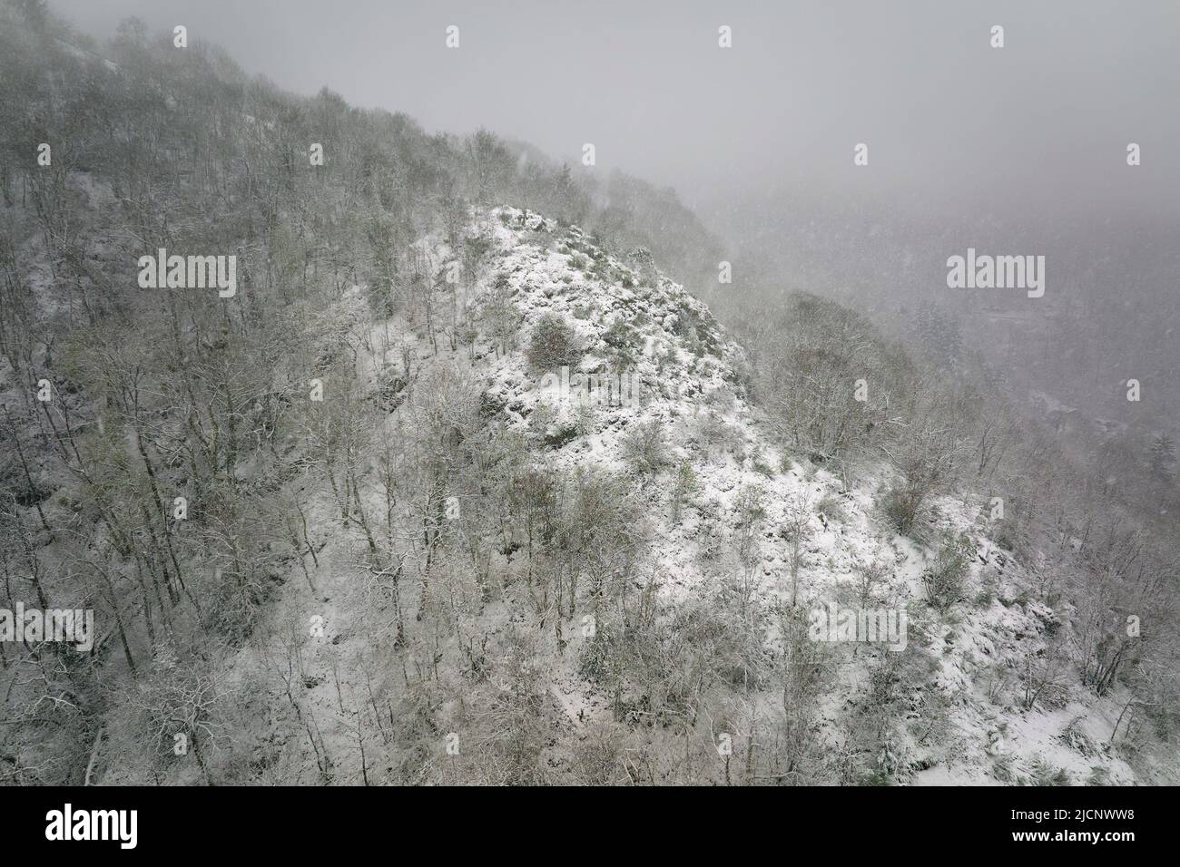 Aerial foggy landscape with mountain cliffs covered with fresh fallen ...