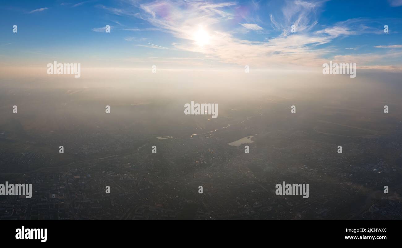 Aerial view from airplane window at high altitude of distant city ...