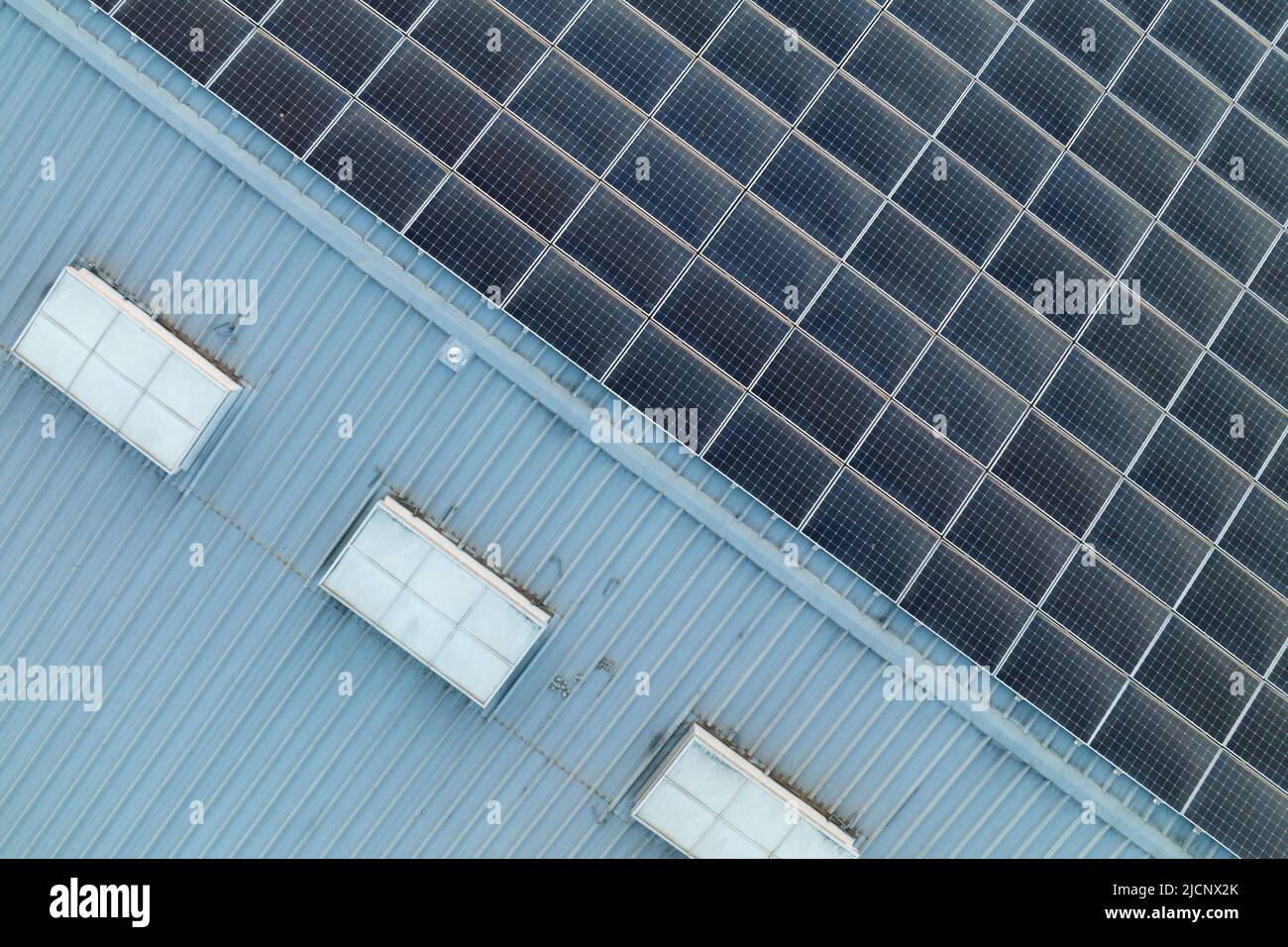 Aerial view of blue photovoltaic solar panels mounted on industrial ...