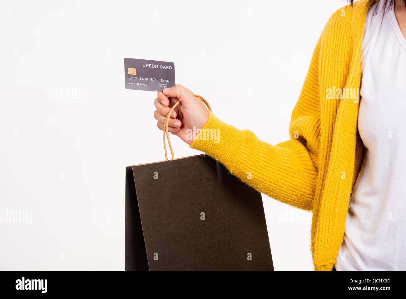 Happy woman hand she wears yellow shirt holding black shopping bags and ...