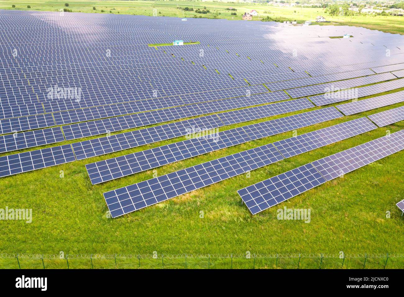 Aerial view of solar power plant on green field. Electric panels for producing clean ecologic ...