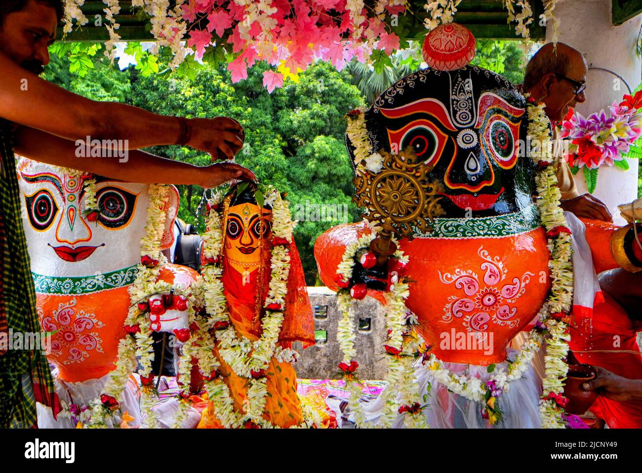 Hindu monks and devotees perform a ritual of bathing Hindu deity idols ...