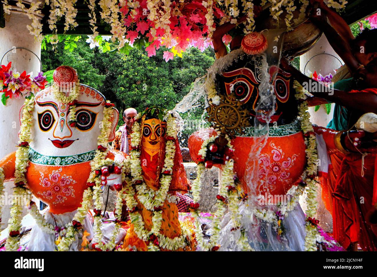 Hindu monks and devotees perform a ritual of bathing Hindu deity idols ...