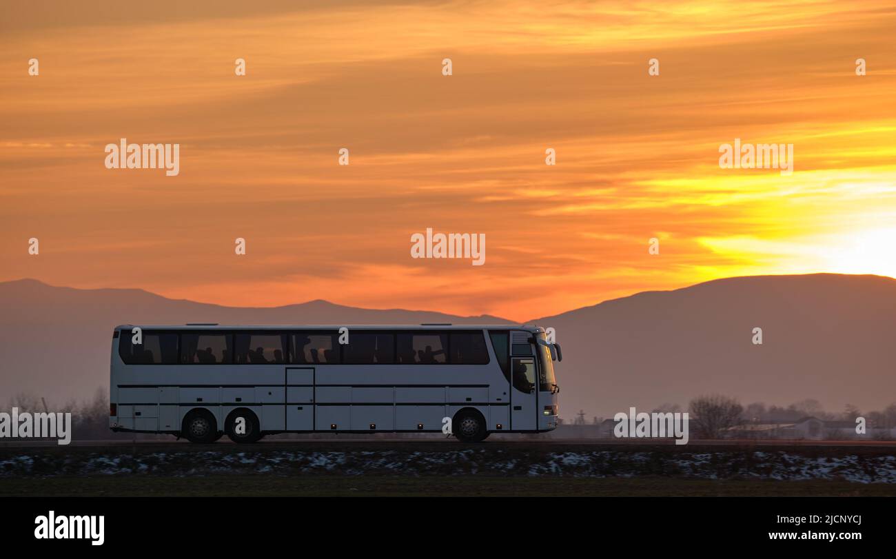 Intercity passenger bus driving on highway road in evening Stock Photo ...