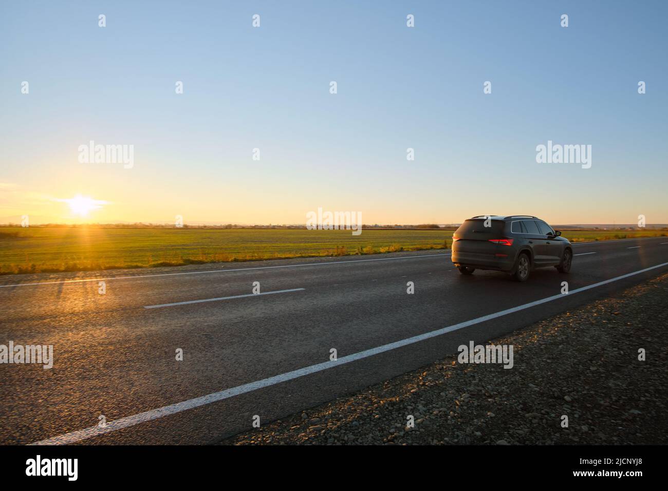 SUV car driving fast on intercity road at sunset. Highway traffic in ...