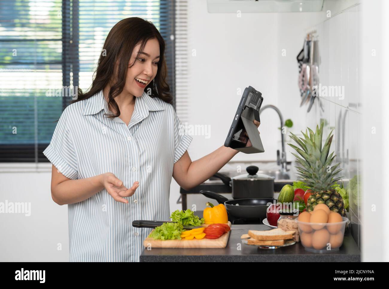cheerful young vlogger woman making video call from digital tablet ...