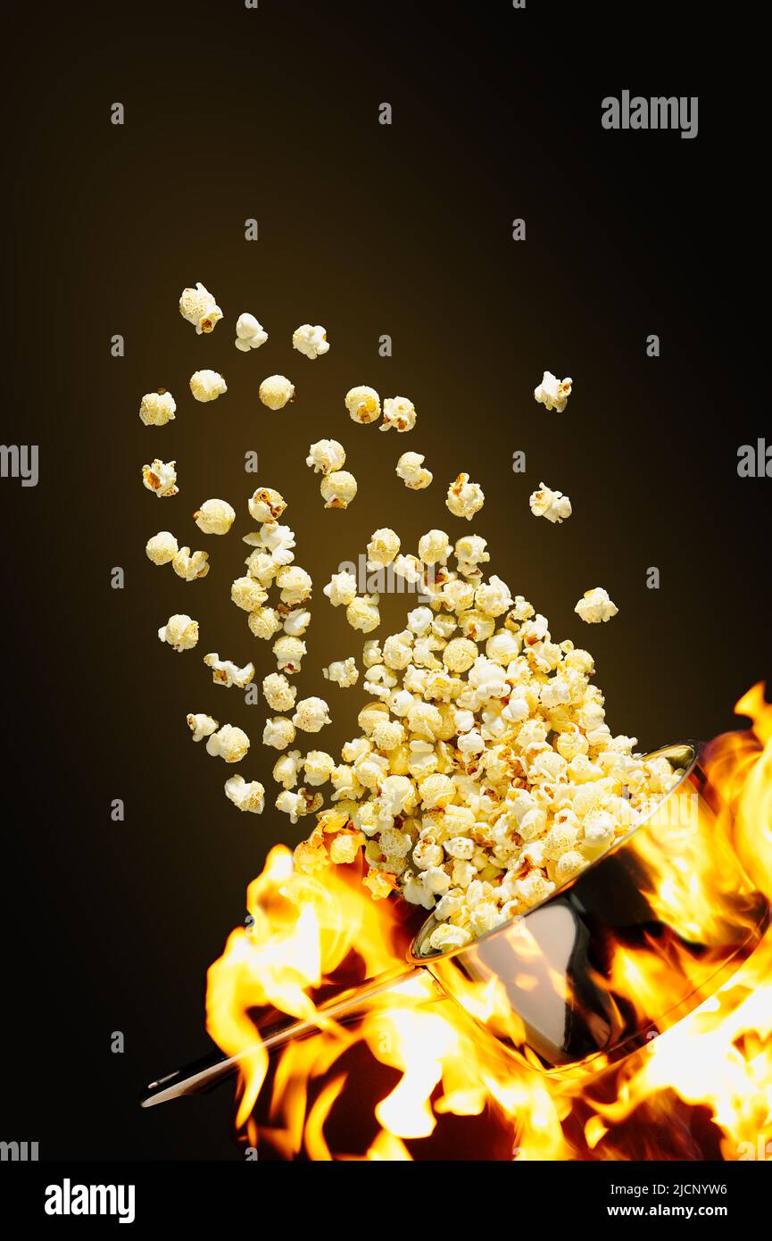 Flying popcorn on a dark background. Hot popcorn flying from pot under ...