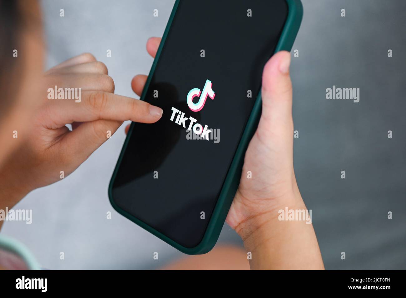 Child holding smartphone with TikTok application icon on Apple iPhone ...