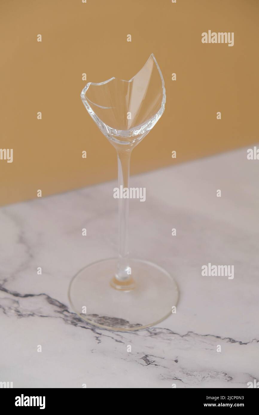 Broken champagne glass on minimal beige background. Creative art ...