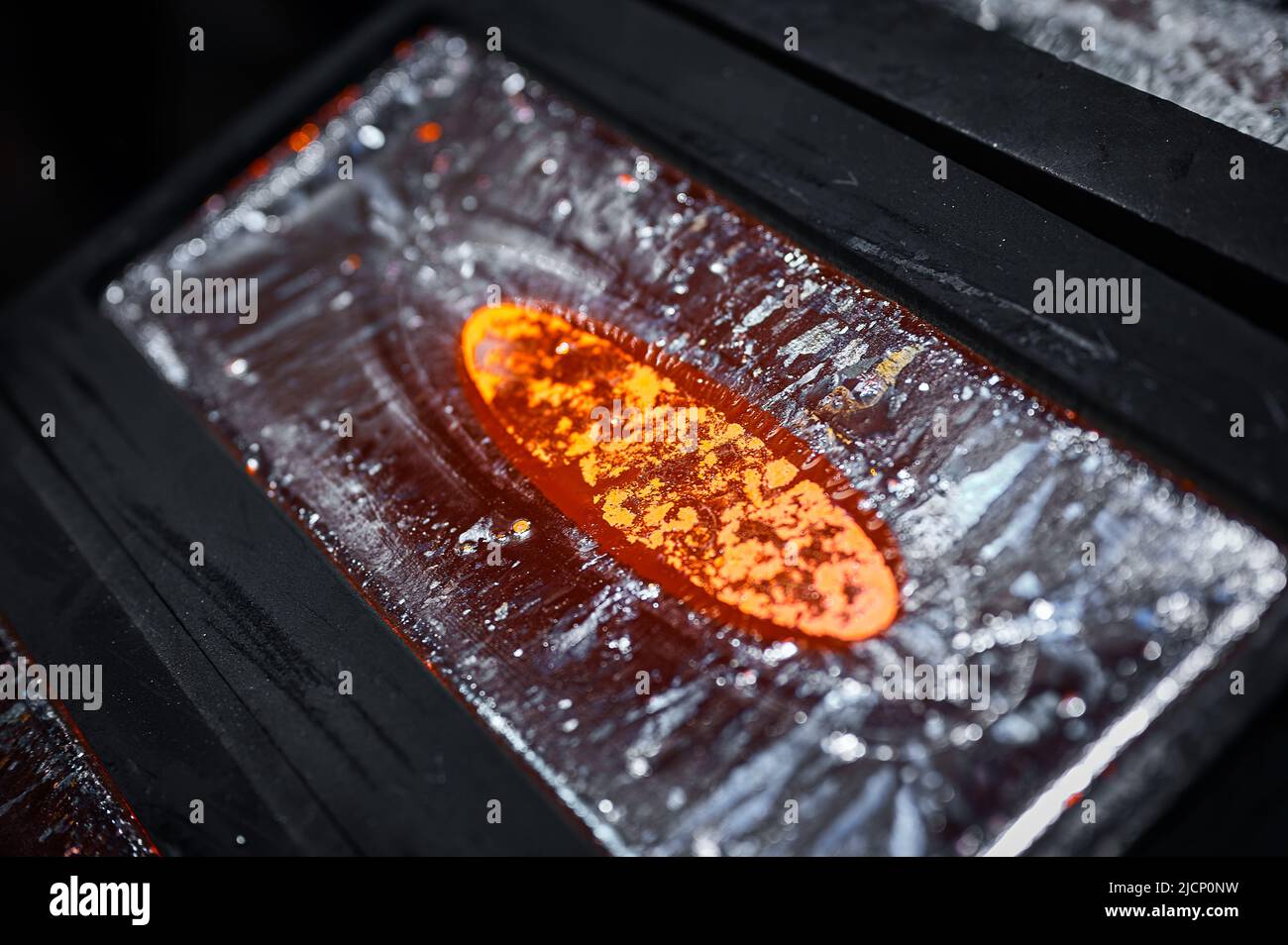 Silver ingot with hot center cools down in casting form Stock Photo - Alamy