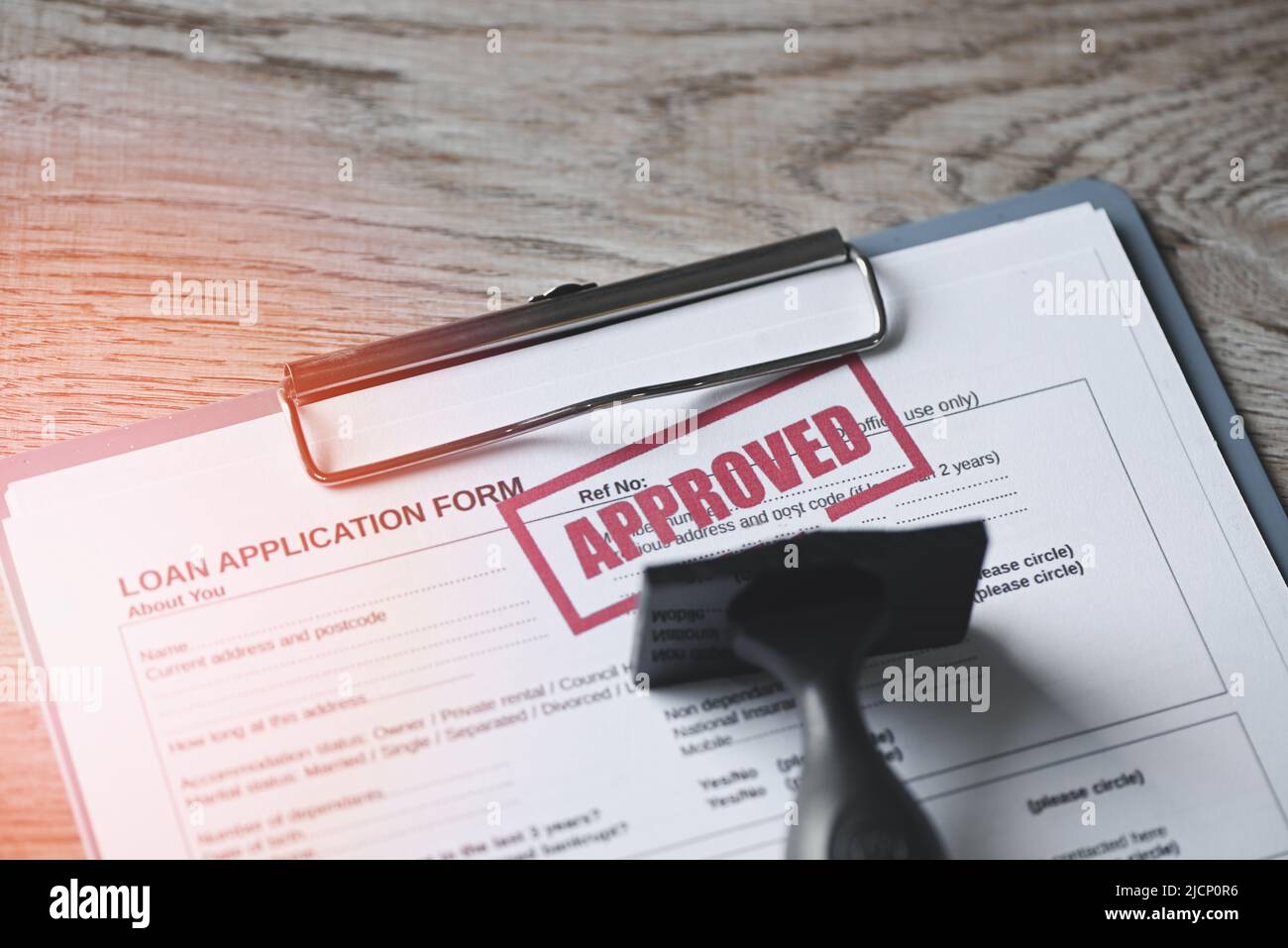 Loan approved on loan application form paper with rubber stamp on table ...