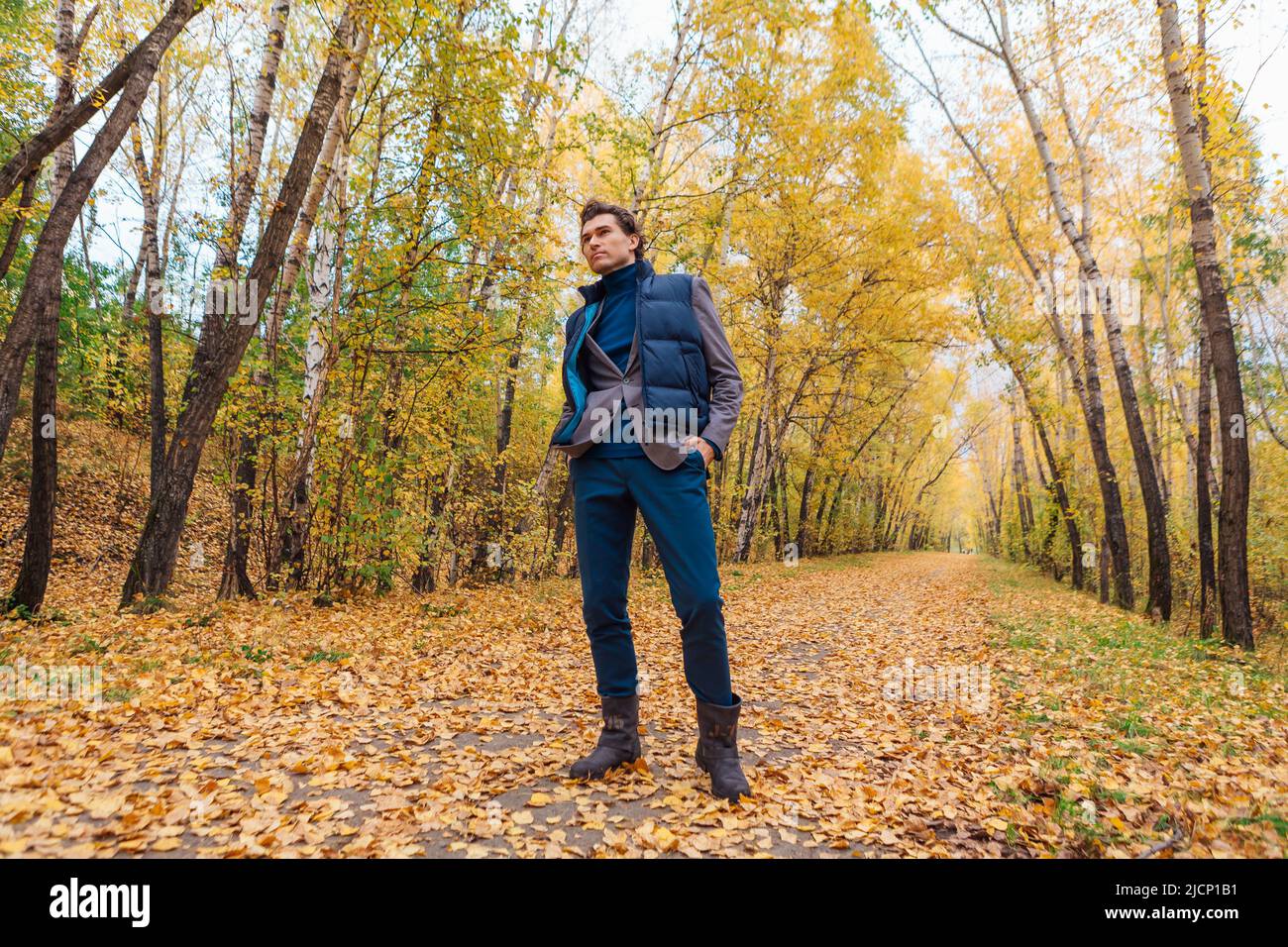 Tall handsome man walking in the autumn alley Stock Photo - Alamy