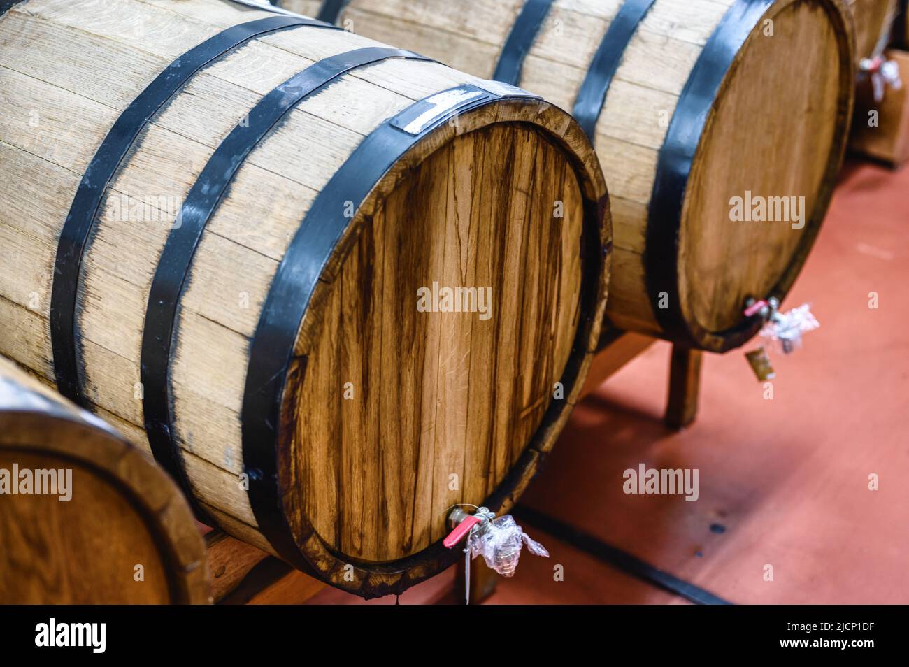 Line of wooden barrels of expensive alcohol drinks at plant Stock Photo ...