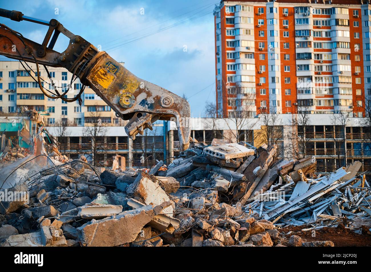 Crusher destroys reinforced concrete at demolition site Stock Photo - Alamy