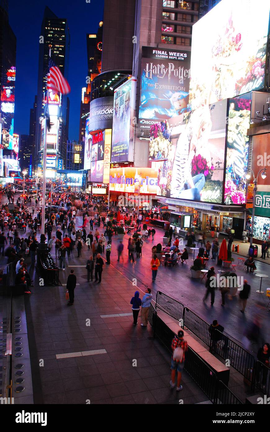 The bight advertising signs illuminate the crowd of people walking ...