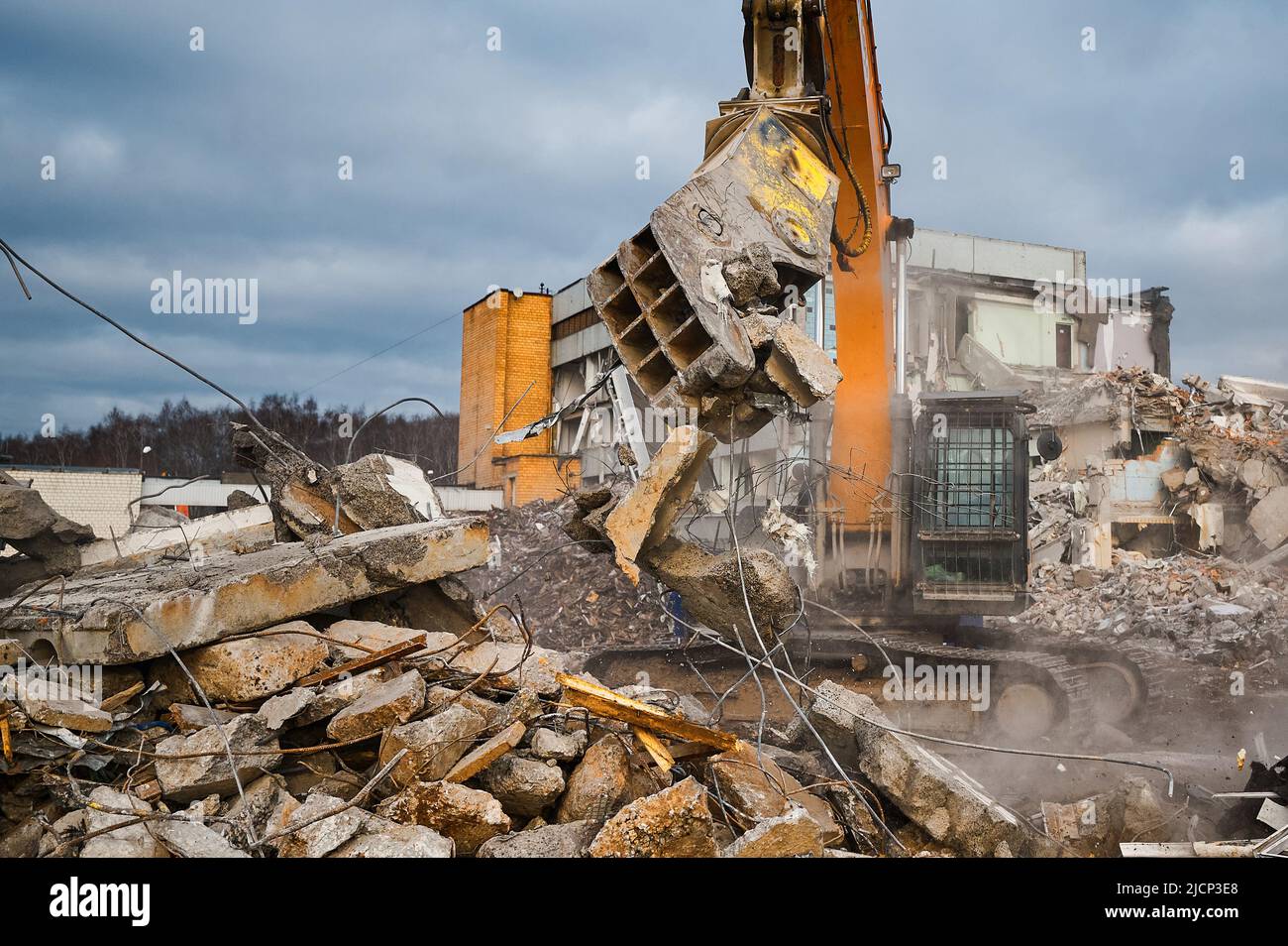 Excavator with hydraulic press breaks concrete leftovers Stock Photo - Alamy