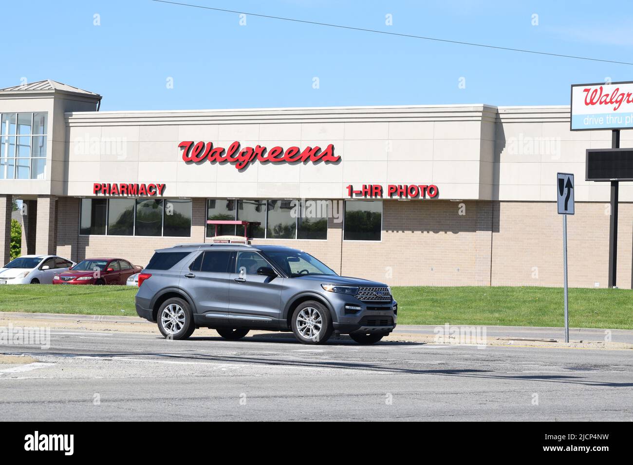 A grey SUV stopped at a traffic light with a Walgreens pharmacy in the ...