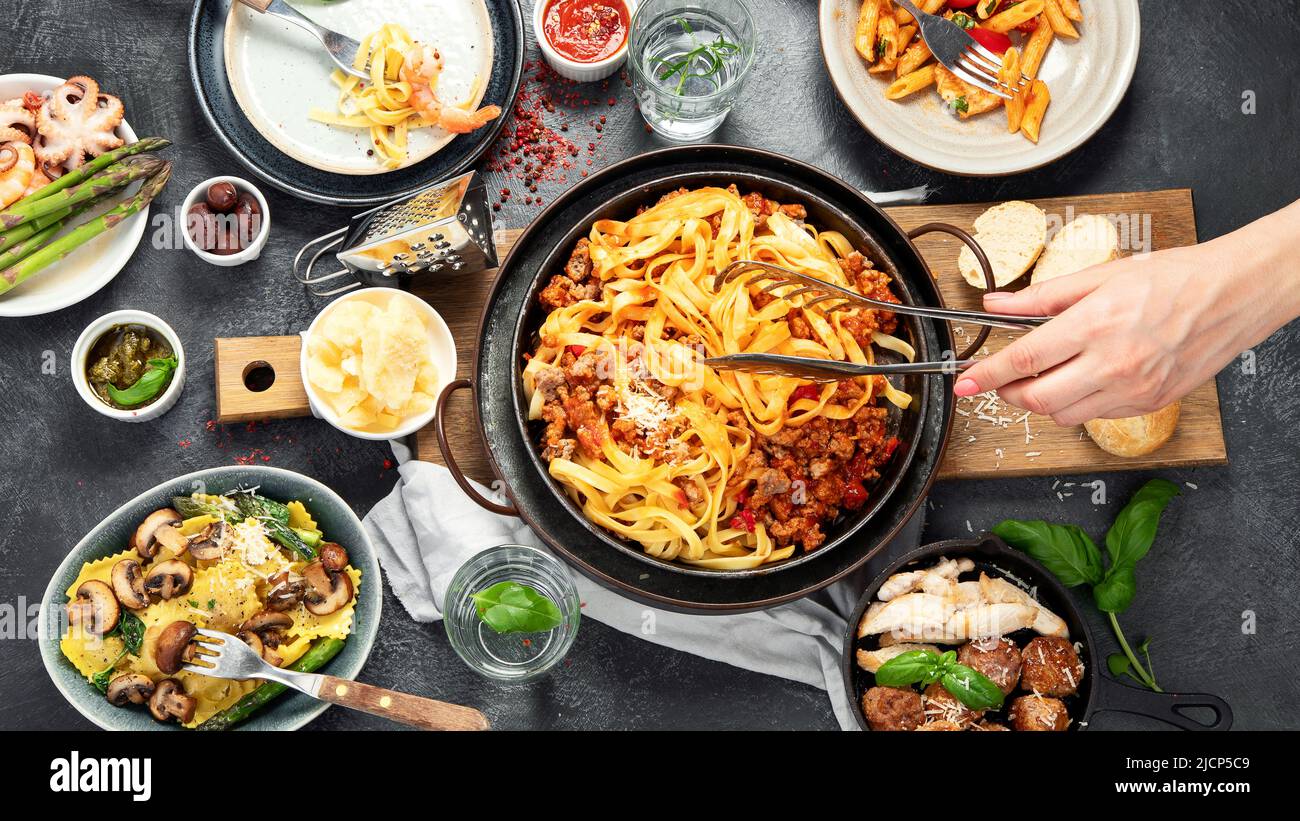 Table of italian meals on plates pasta Bolognese, ravioli, penne with ...