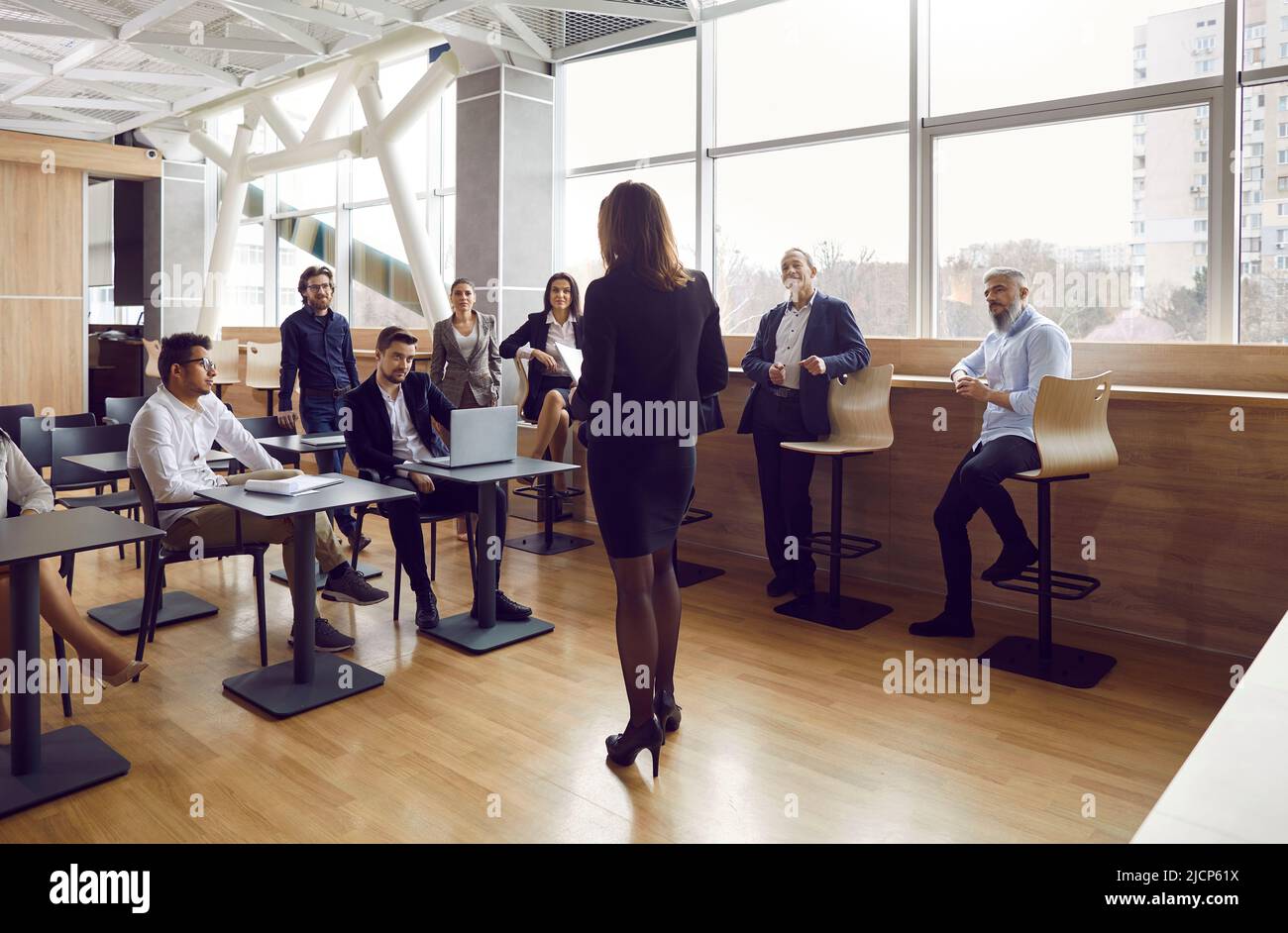 Group of diverse business people listen to speech by female speaker at ... Group of diverse business people listen to speech by female speaker at ...