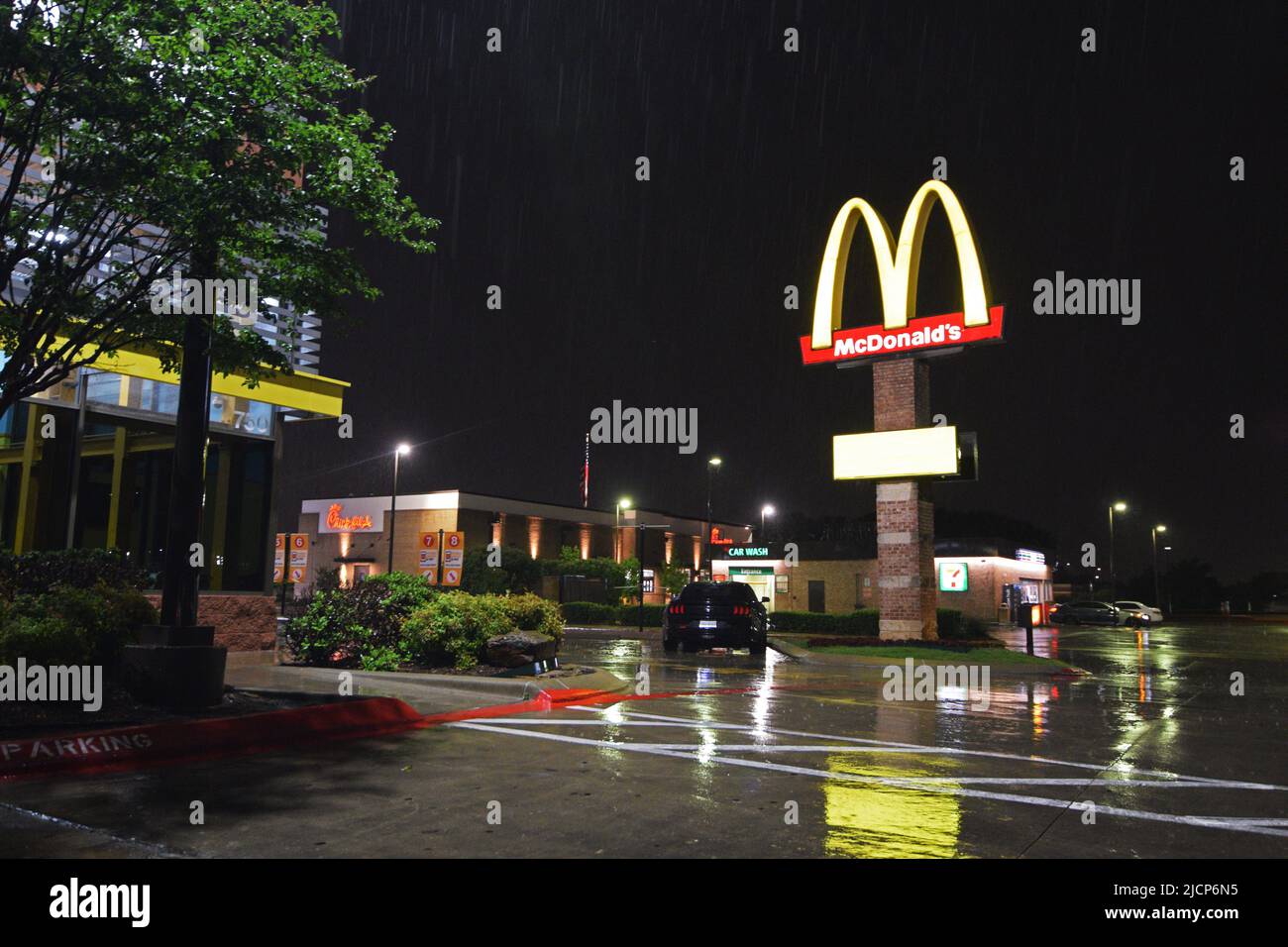 The lights of a McDonald's fast food restaurant refelct in a parking ...