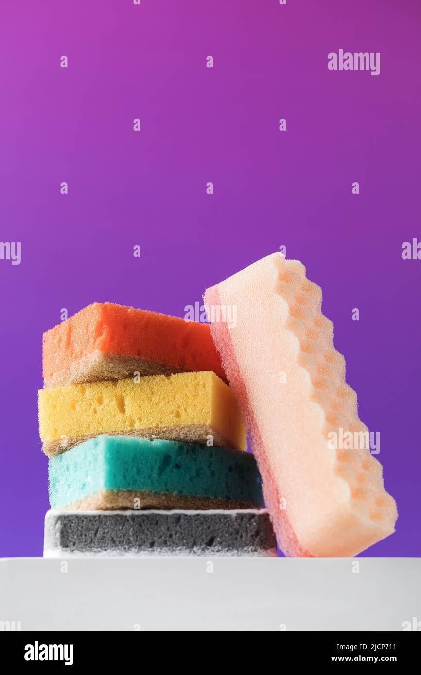 Different sponges to wash up on purple background closeup. Cleaning ...