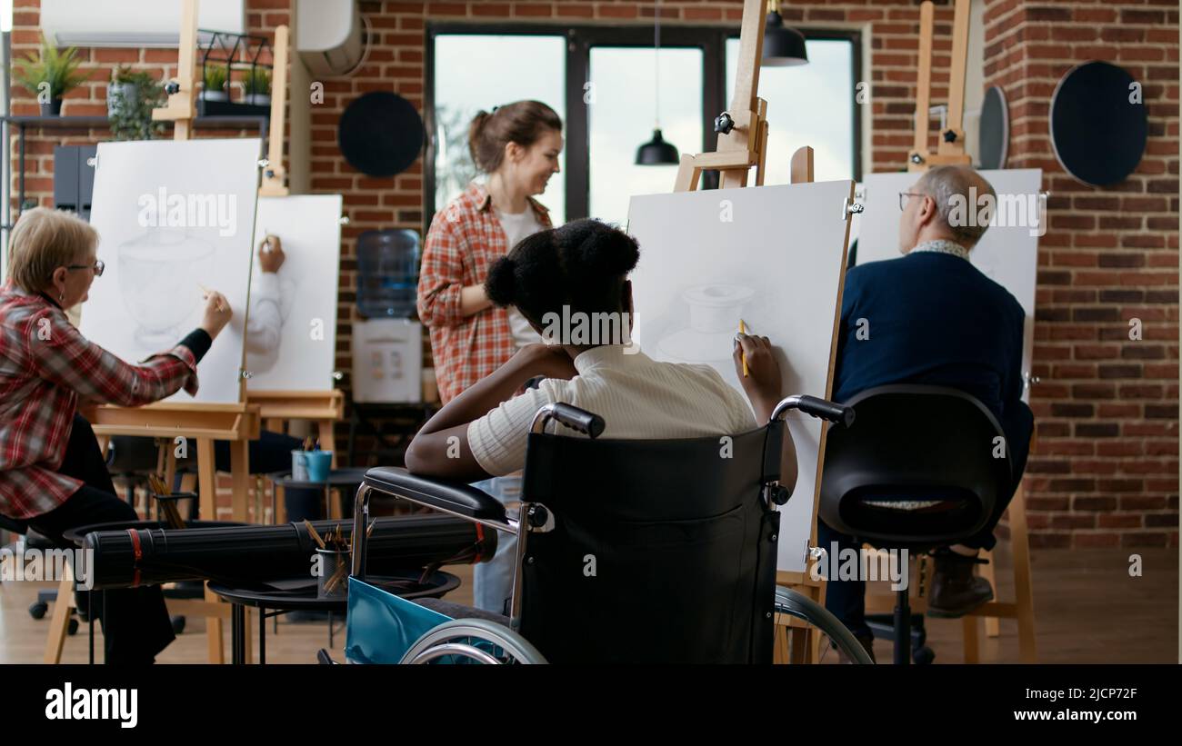 Young woman with disability learning to draw sketch on canvas ...