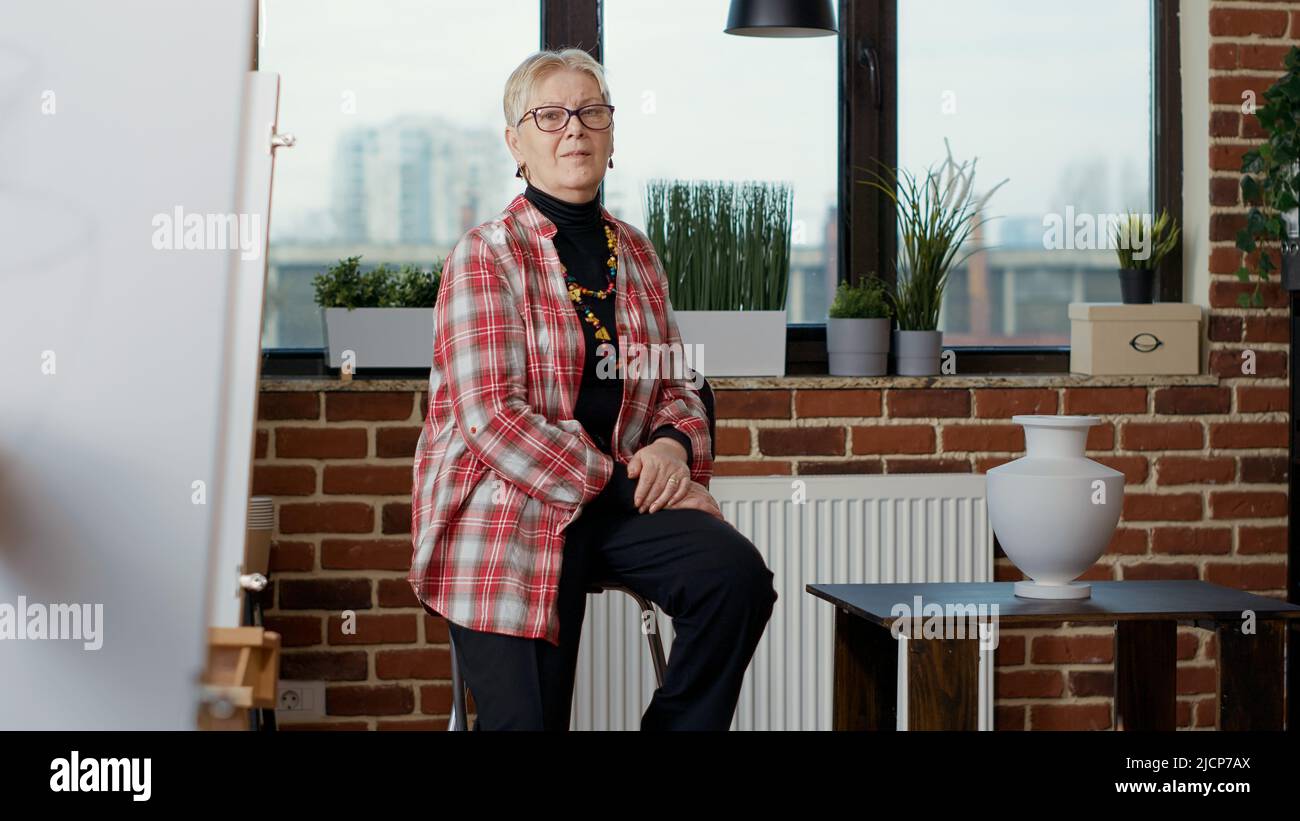 Portrait of elder teacher training art students to draw artistic sketch ...