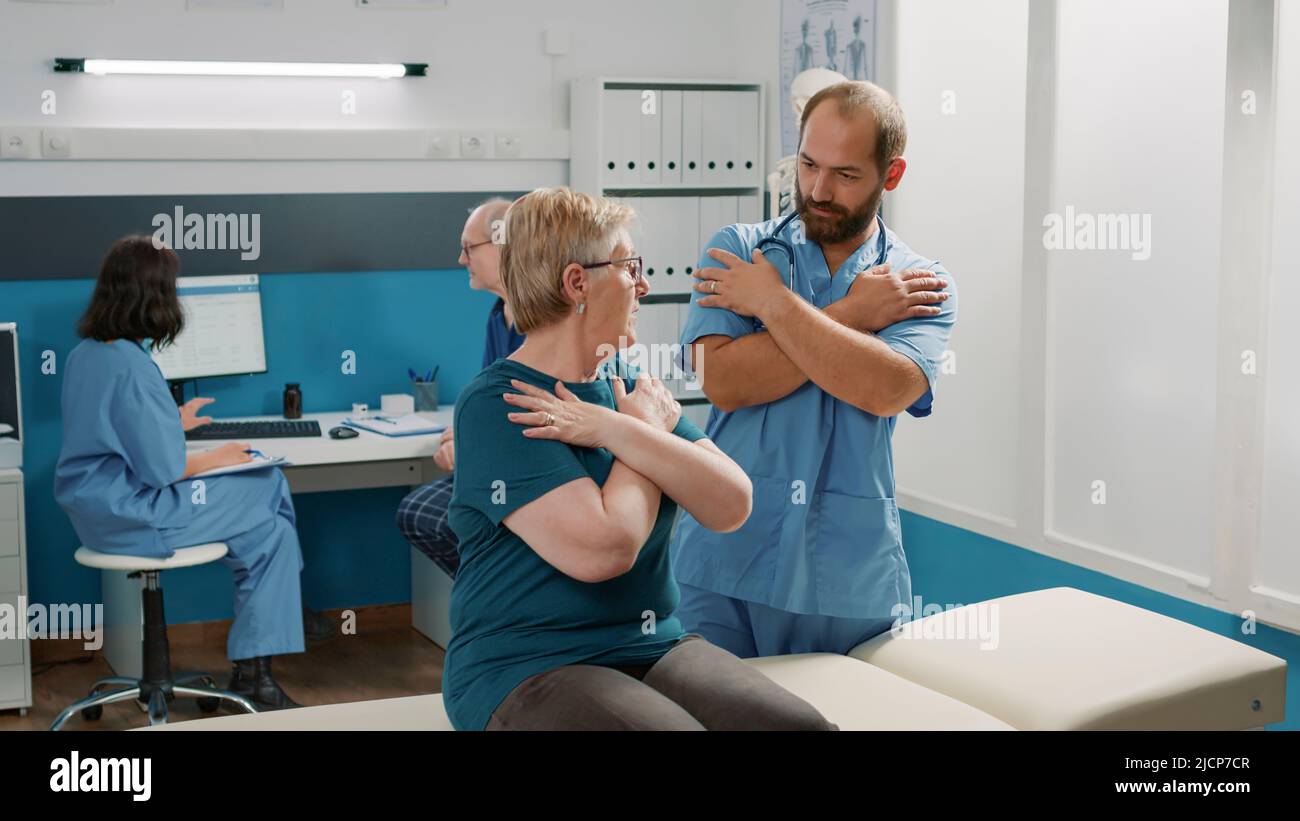 Physiotherapist cracking back bones to help senior patient, increase ...