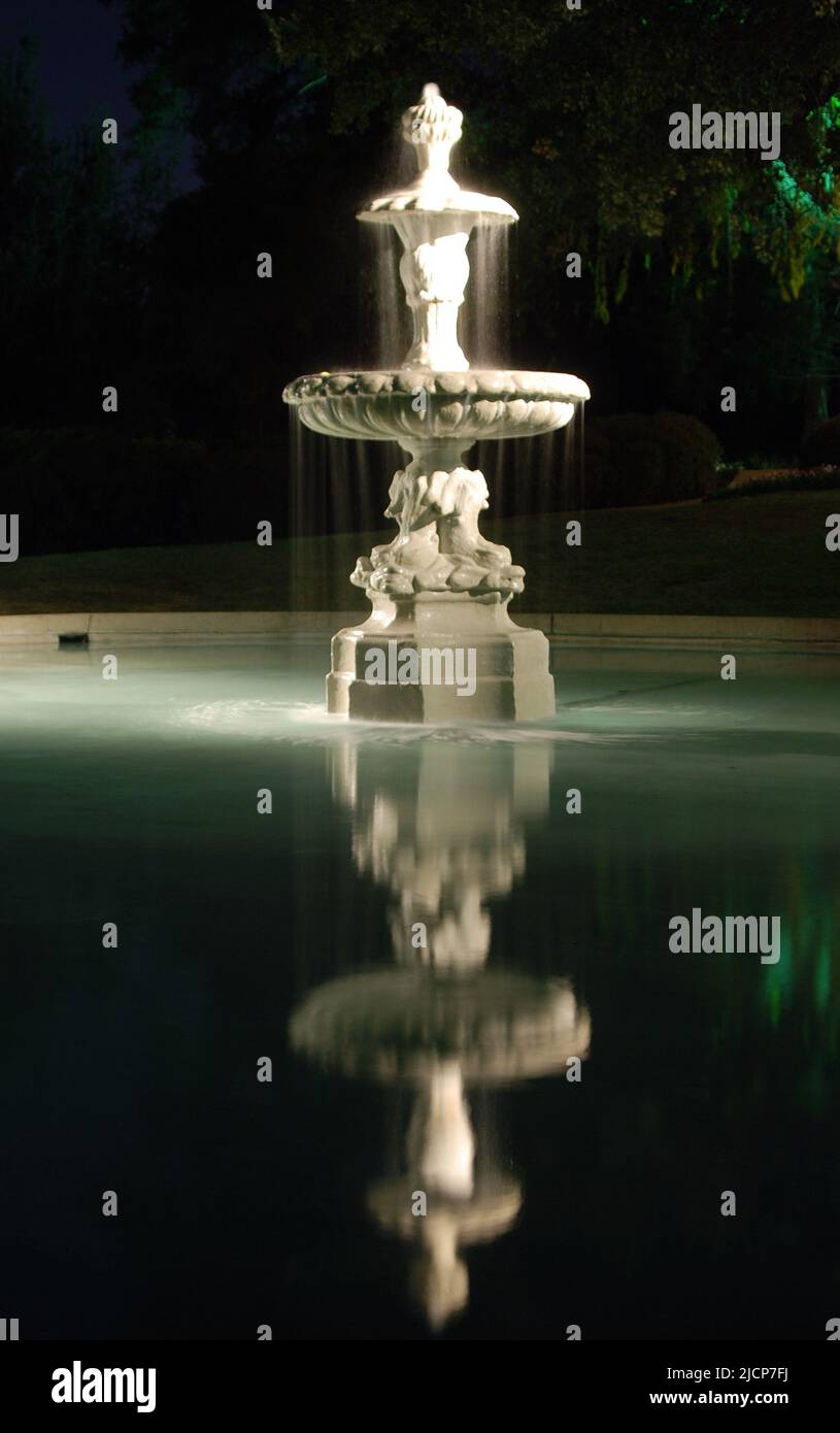 Water fountain and reflection at night in a private park in Highland ...
