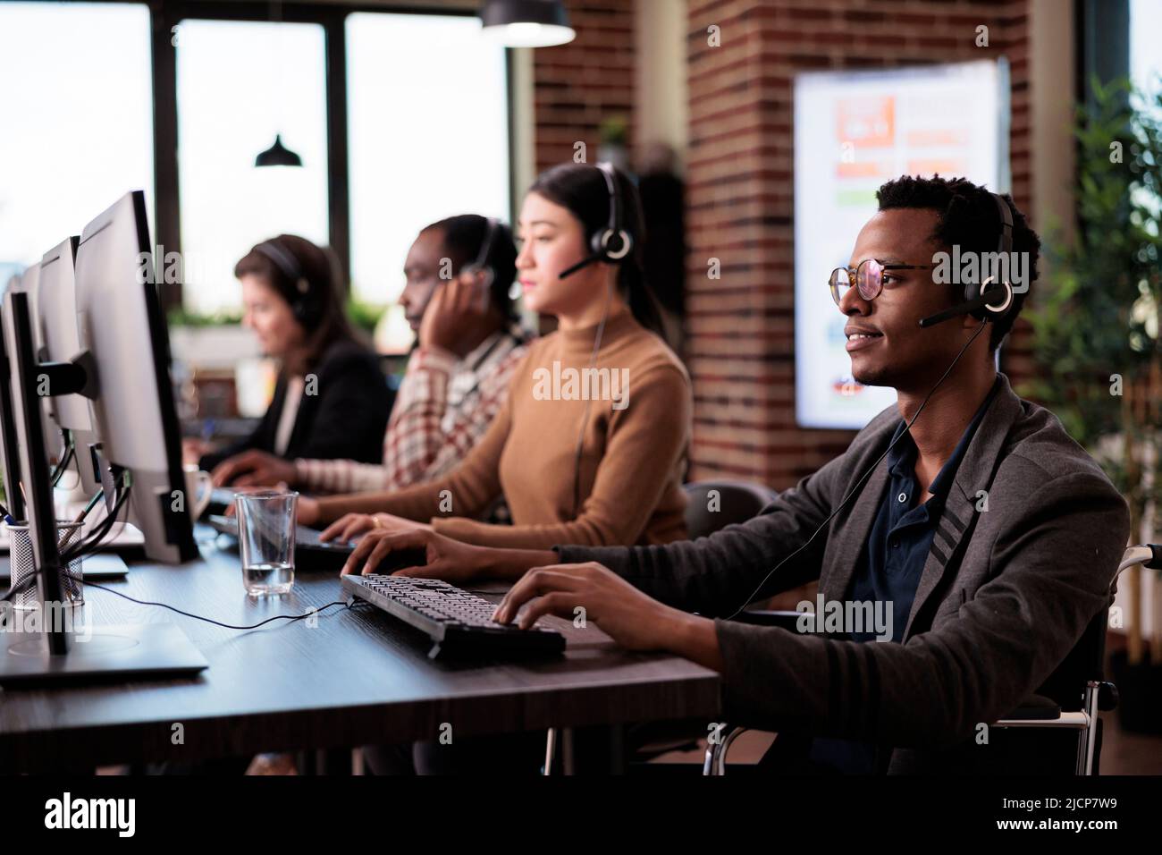 Helpline operator with chronic impairment sitting in wheelchair and ...