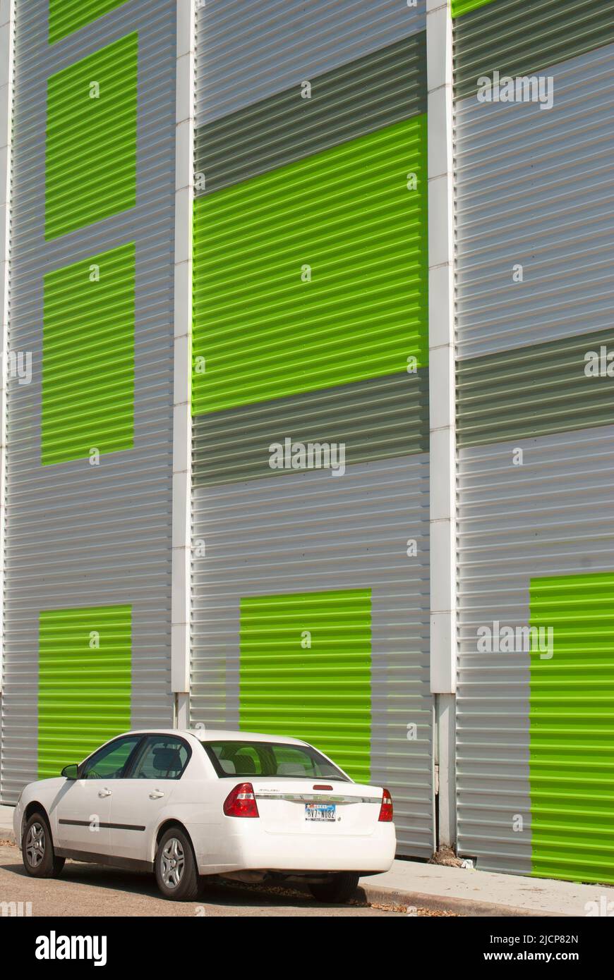White car parked in front of a green and silver painted building Stock ...