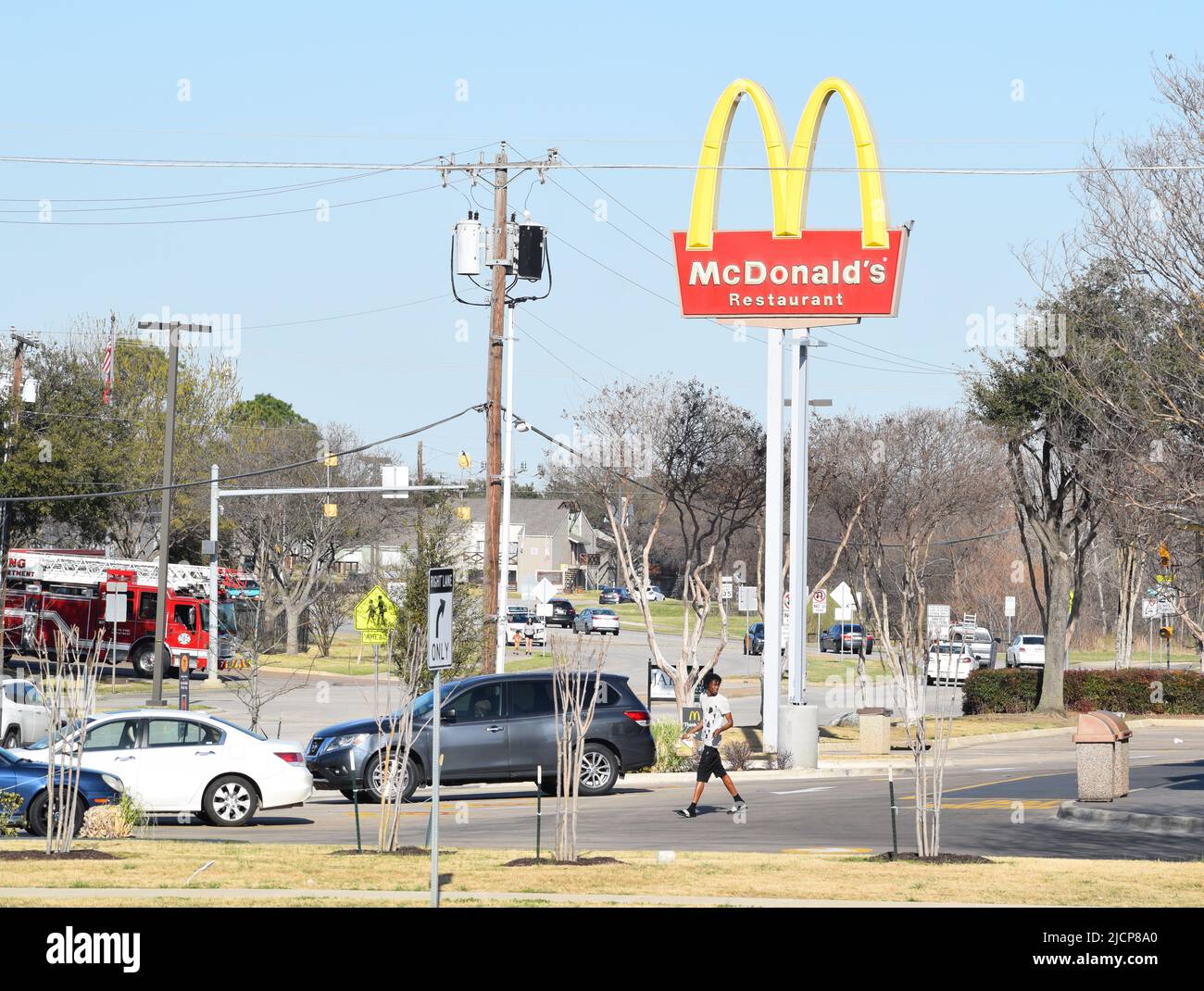 Man walking through a parking lot of a McDonald's fast food restaurant ...