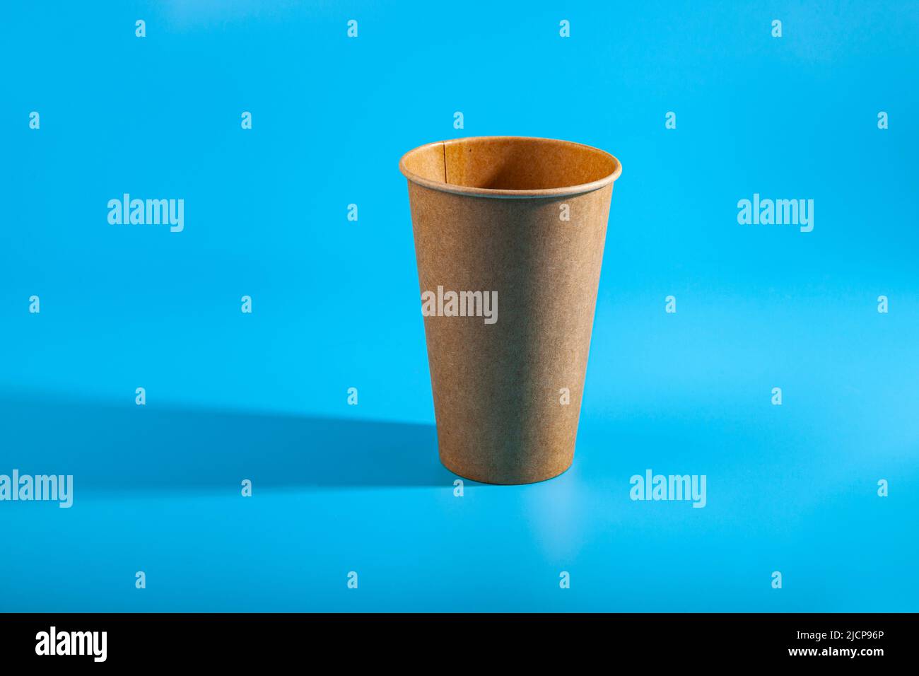 Disposable paper biodegradable cup on a blue background. Top view. Flat ...