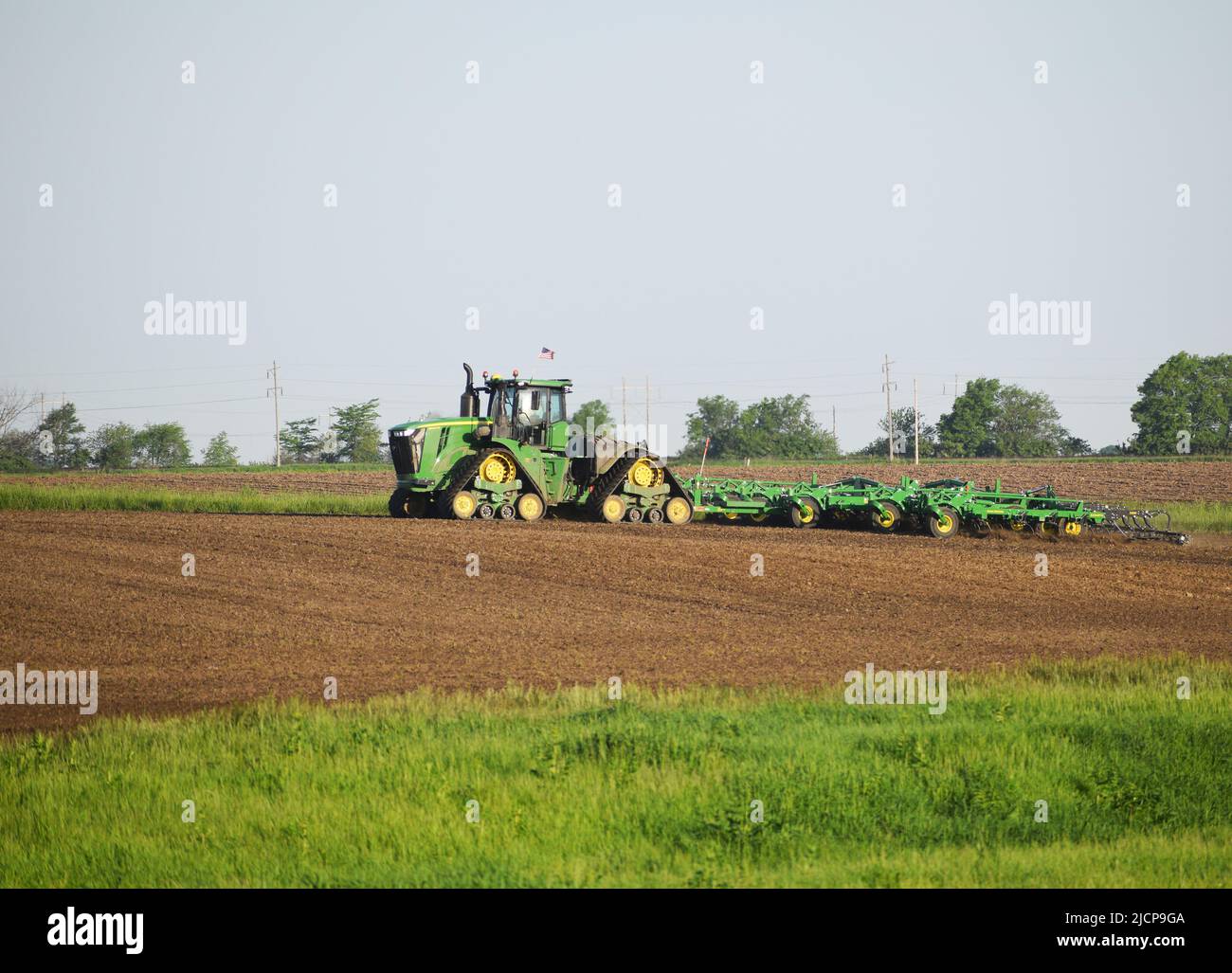 A farmer driving a John Deere 9620 RX tractor on a field in rural east ...