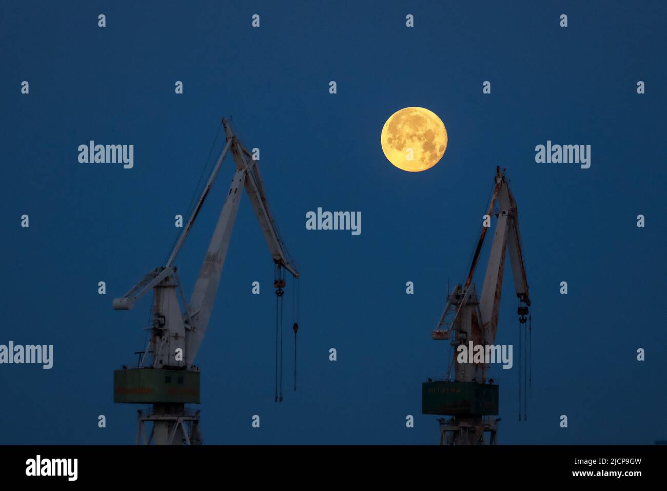 Strawberry Full Moon sets behind cranes at Uljanik Shipyard, in Pula ...